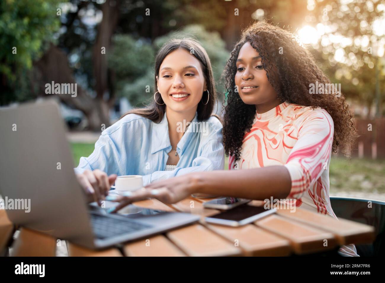 Happy Multiethnic Female Friends Using Laptop Computer Together ...