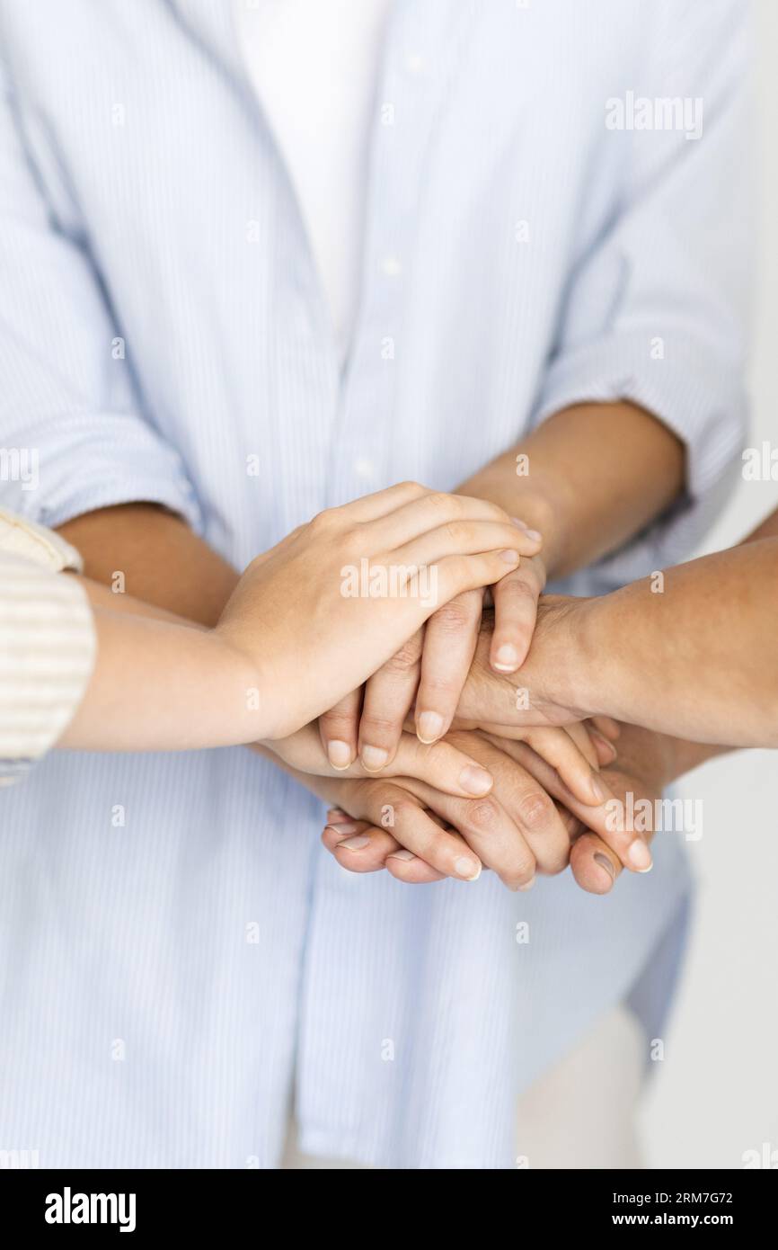European senior woman, teen girl and adult mom put hands on hands Stock ...