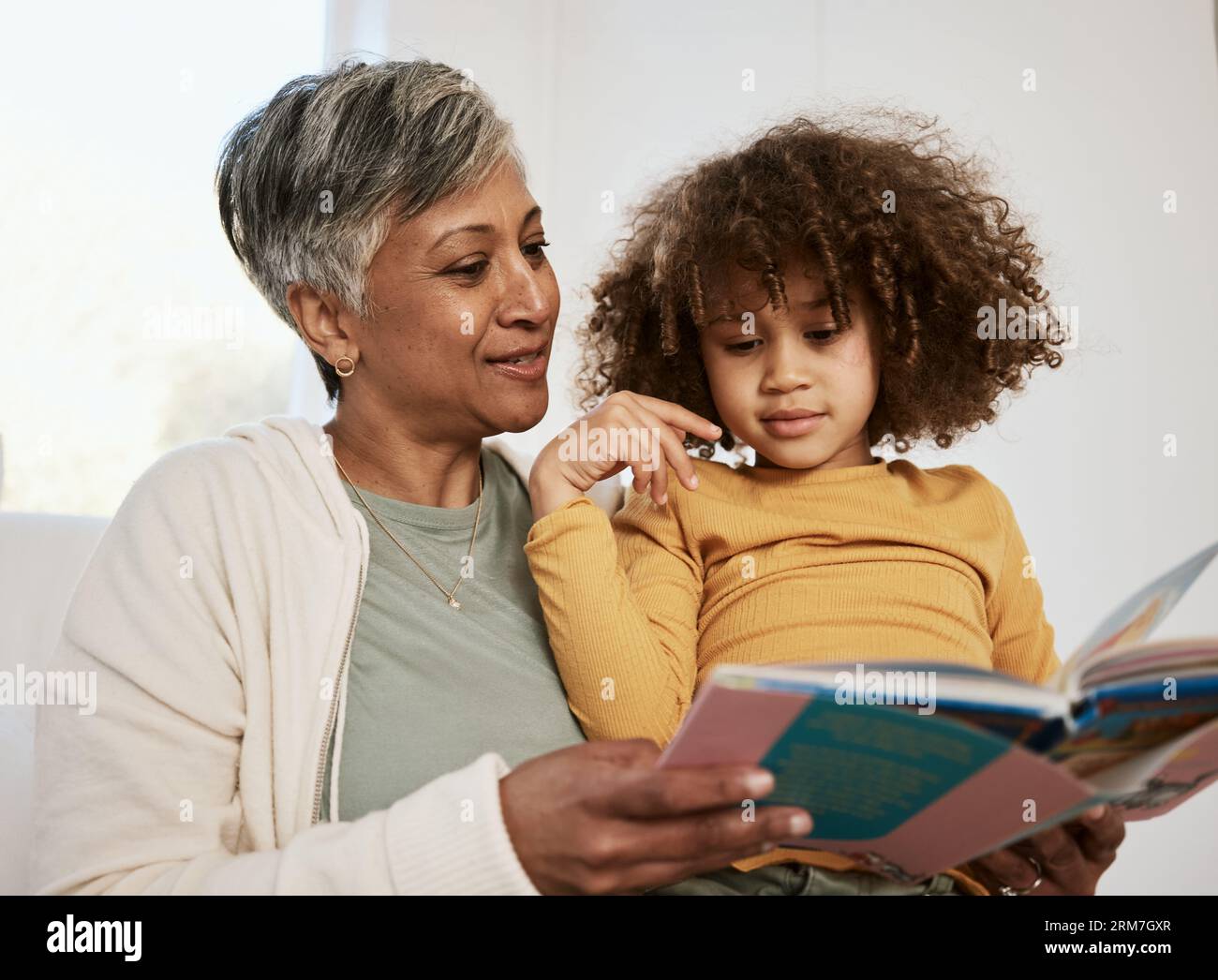 Home, grandmother and young child reading book, cartoon comic and ...