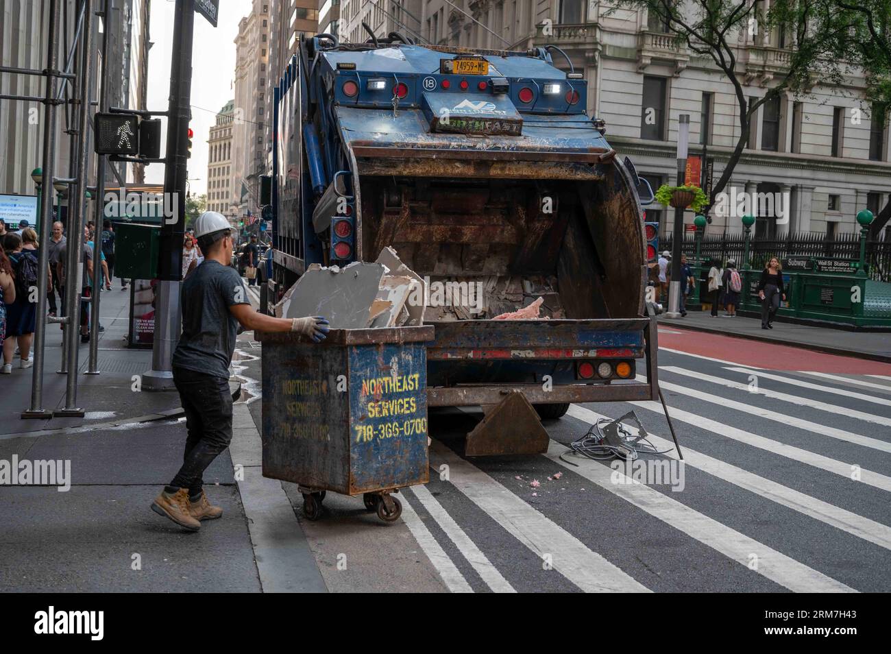 New York, NY, USA, 07-18-2023 Sanitation workers roll trash bins to ...