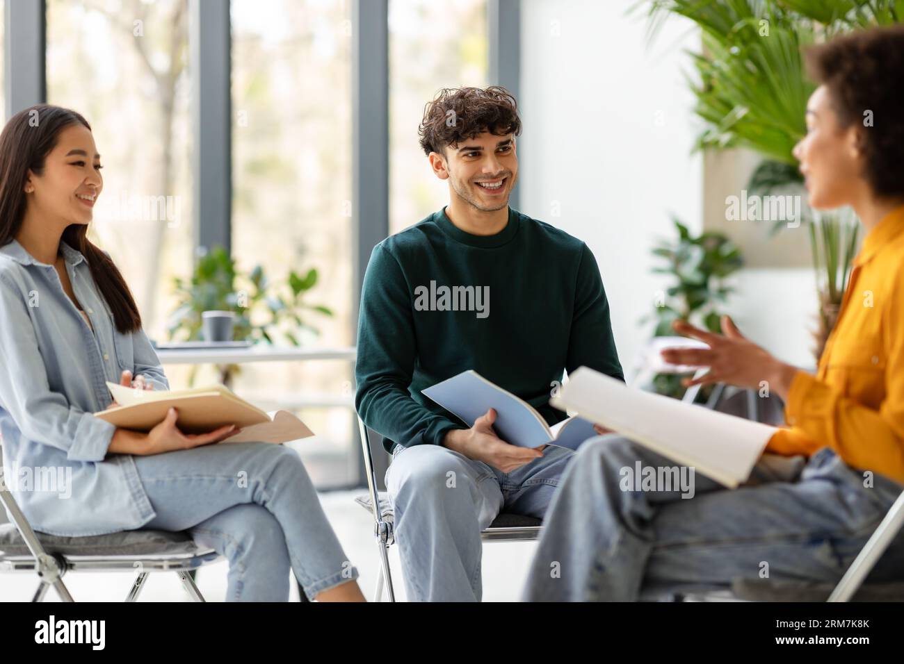 Happy multiracial students friends talking and discussing educational ...