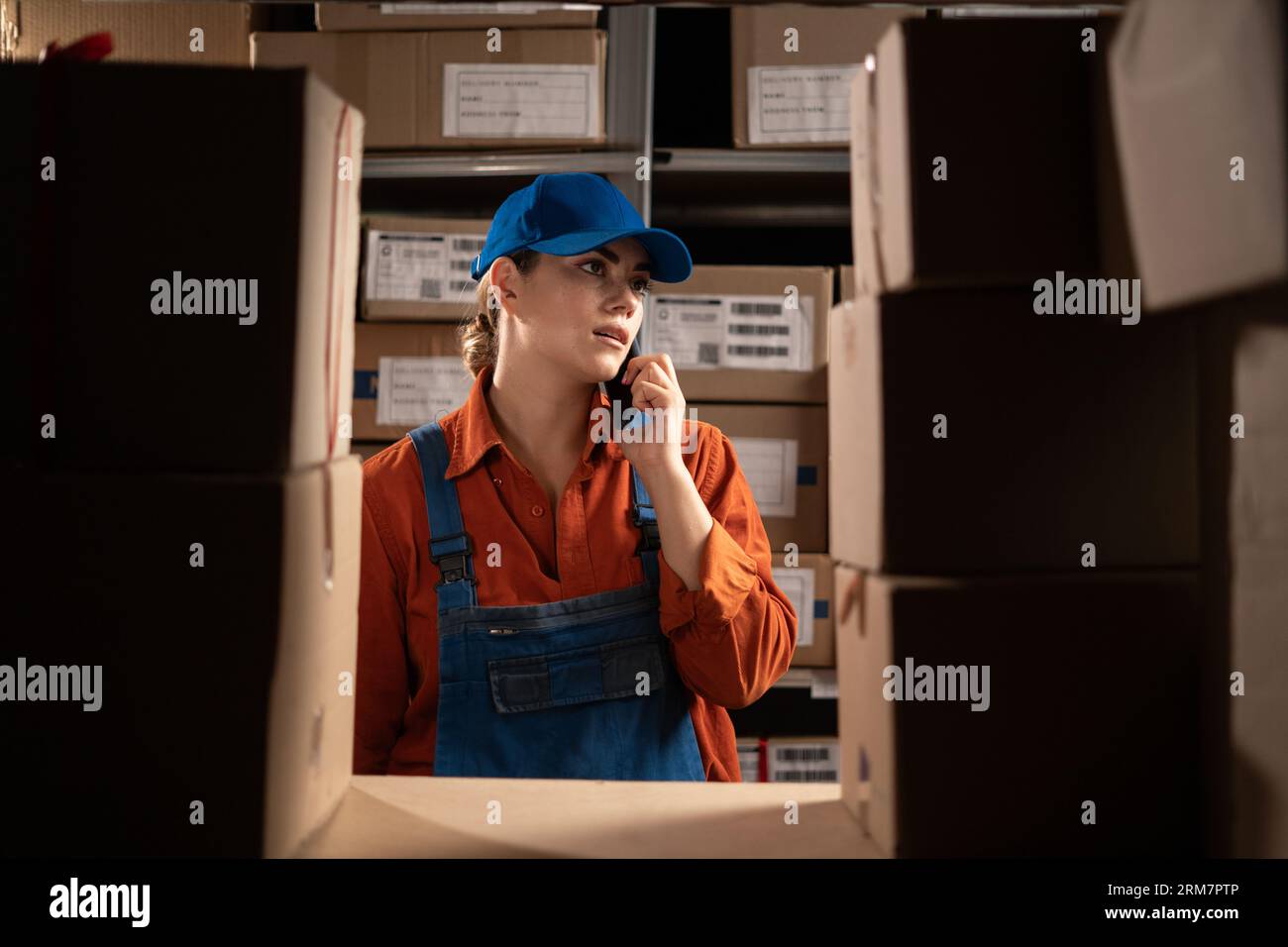 Young online seller talking confirming orders from customer on phone ...