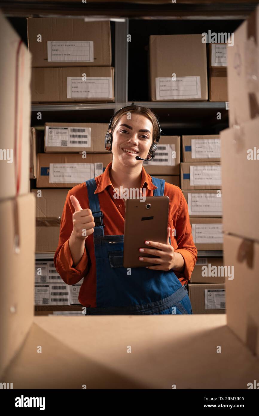 Warehouse inventory manager using digital tablet showing thumbs up ...