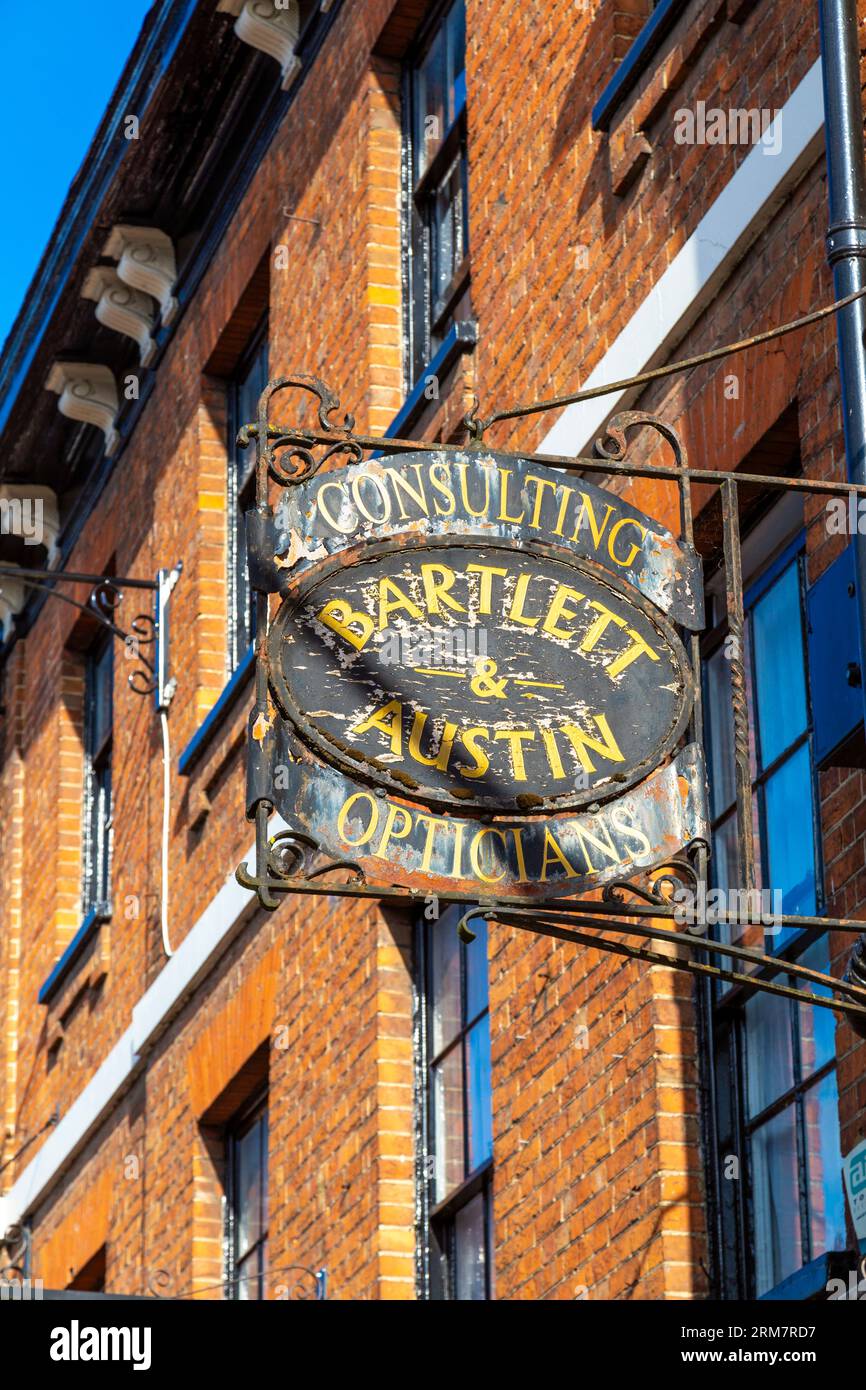 Worn out sign for Bartlett & Austin opticians in Farnham's West Street ...
