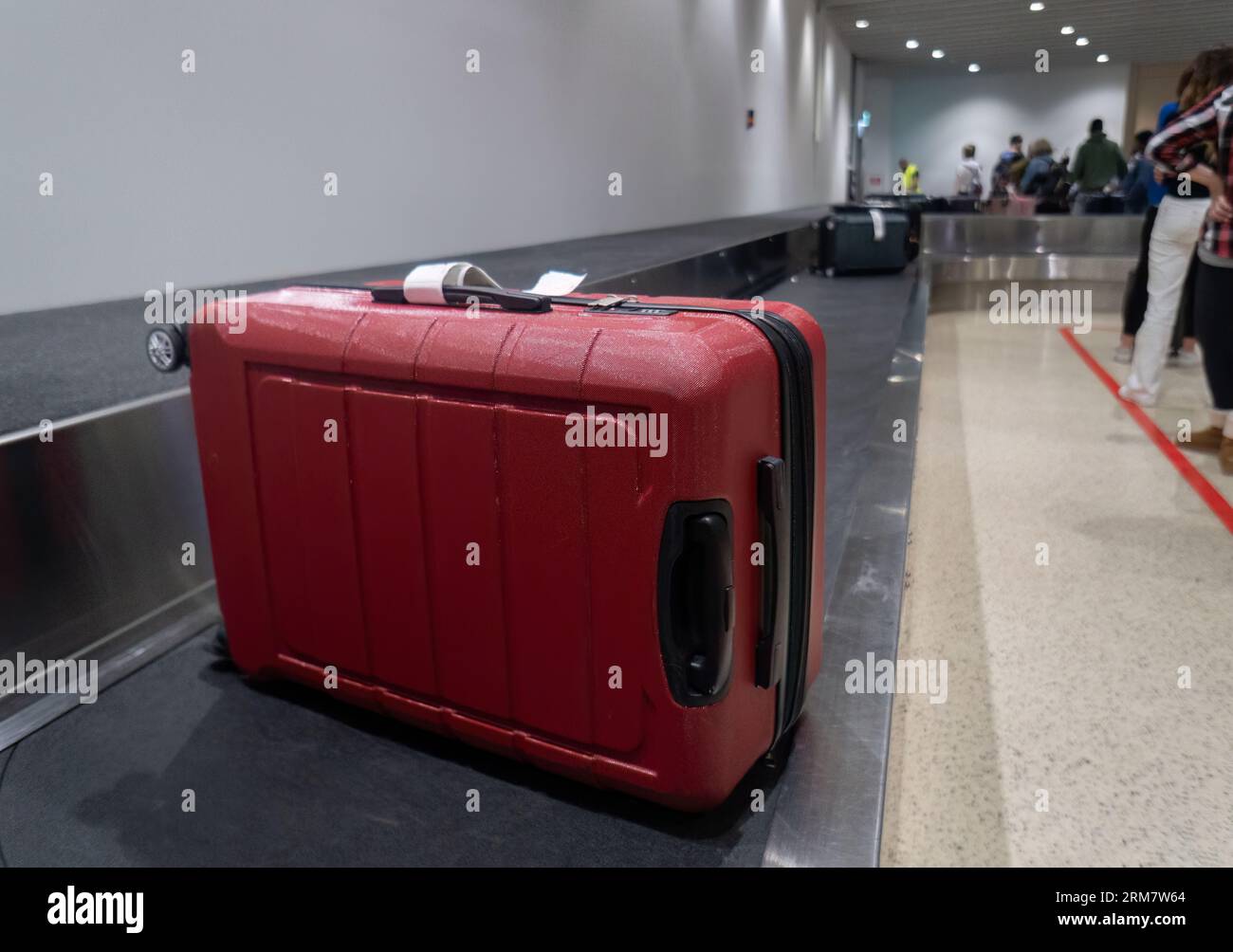 Suitcases on luggage conveyor belt in baggage claim at airport ...