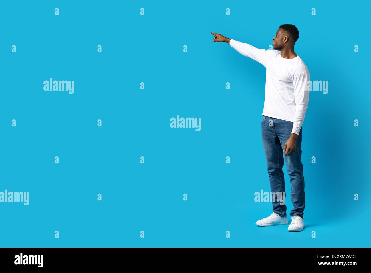 Handsome black guy pointing at copy space, touching something invisible ...
