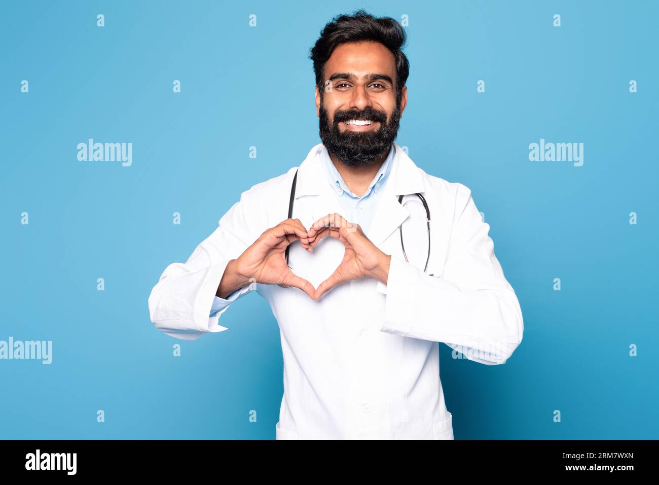 Healthcare professional. Happy indian male doctor showing heart gesture ...