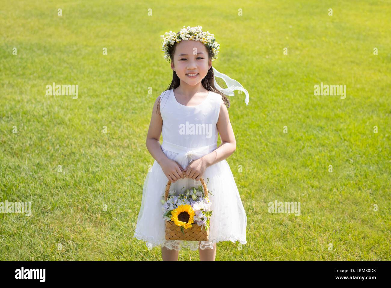 Cute flower girl standing on the grass Stock Photo - Alamy