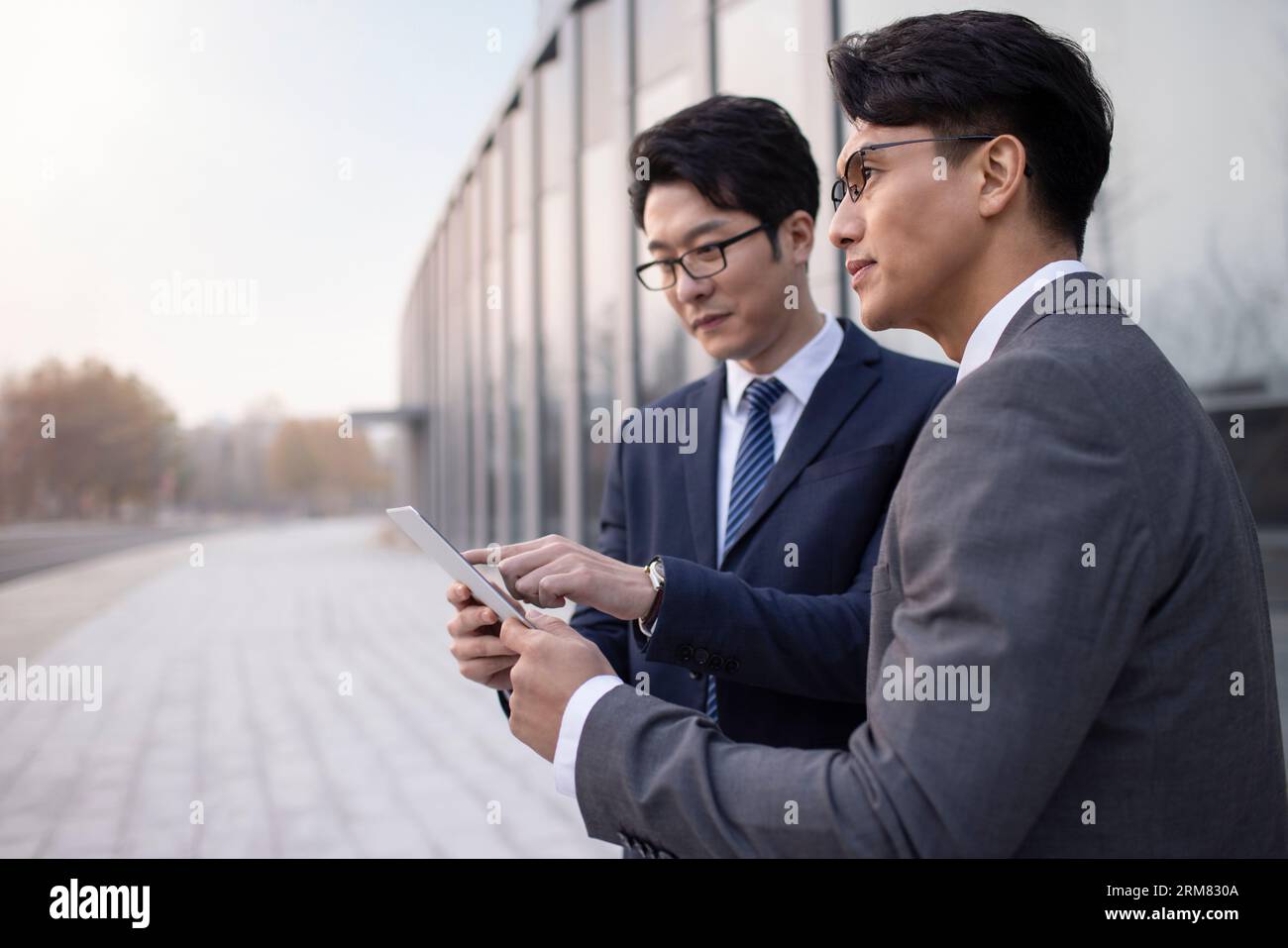 Confident Chinese business people talking outdoors Stock Photo - Alamy
