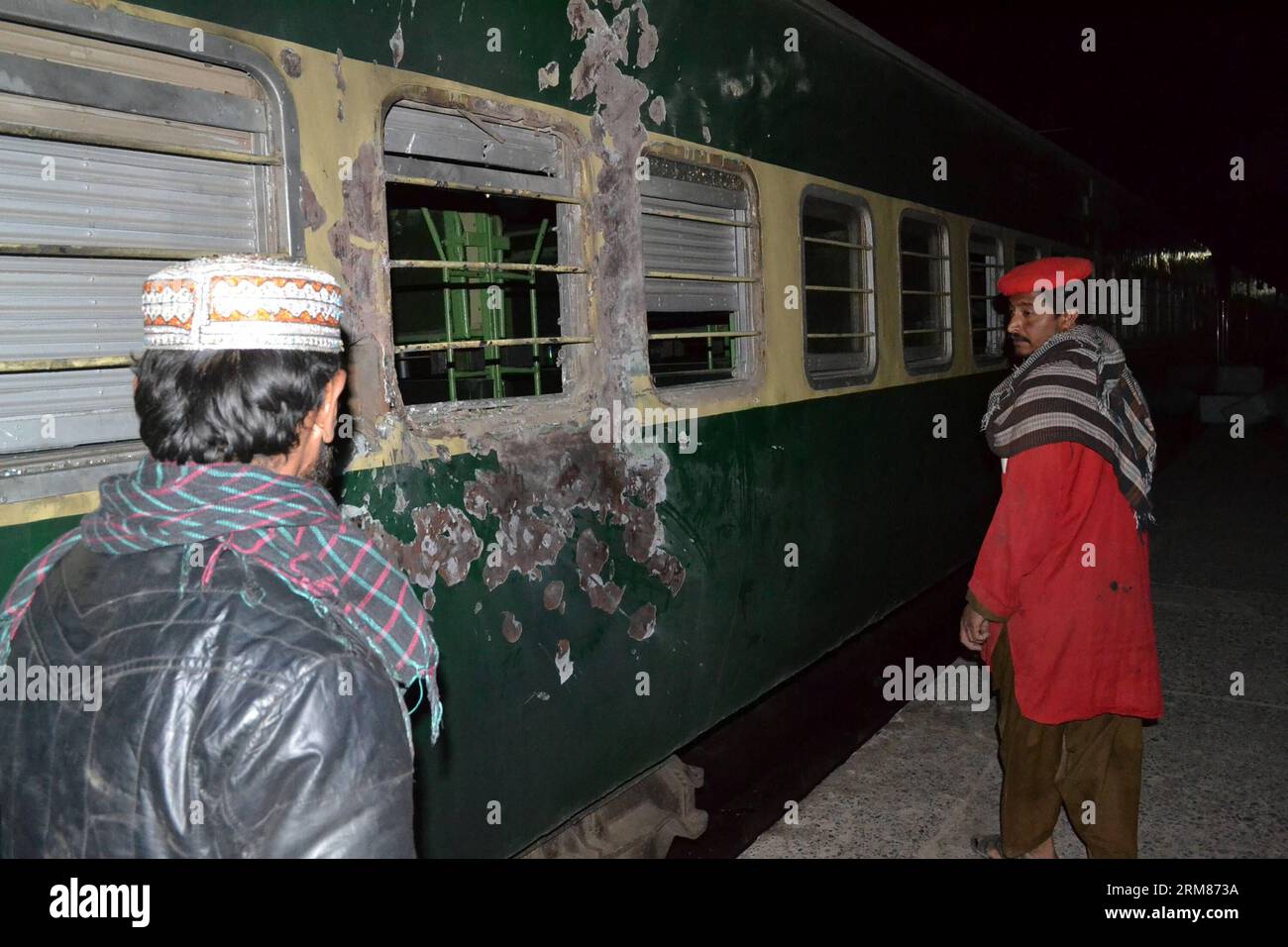 People examine a damaged compartment of a train at a railway station in ...
