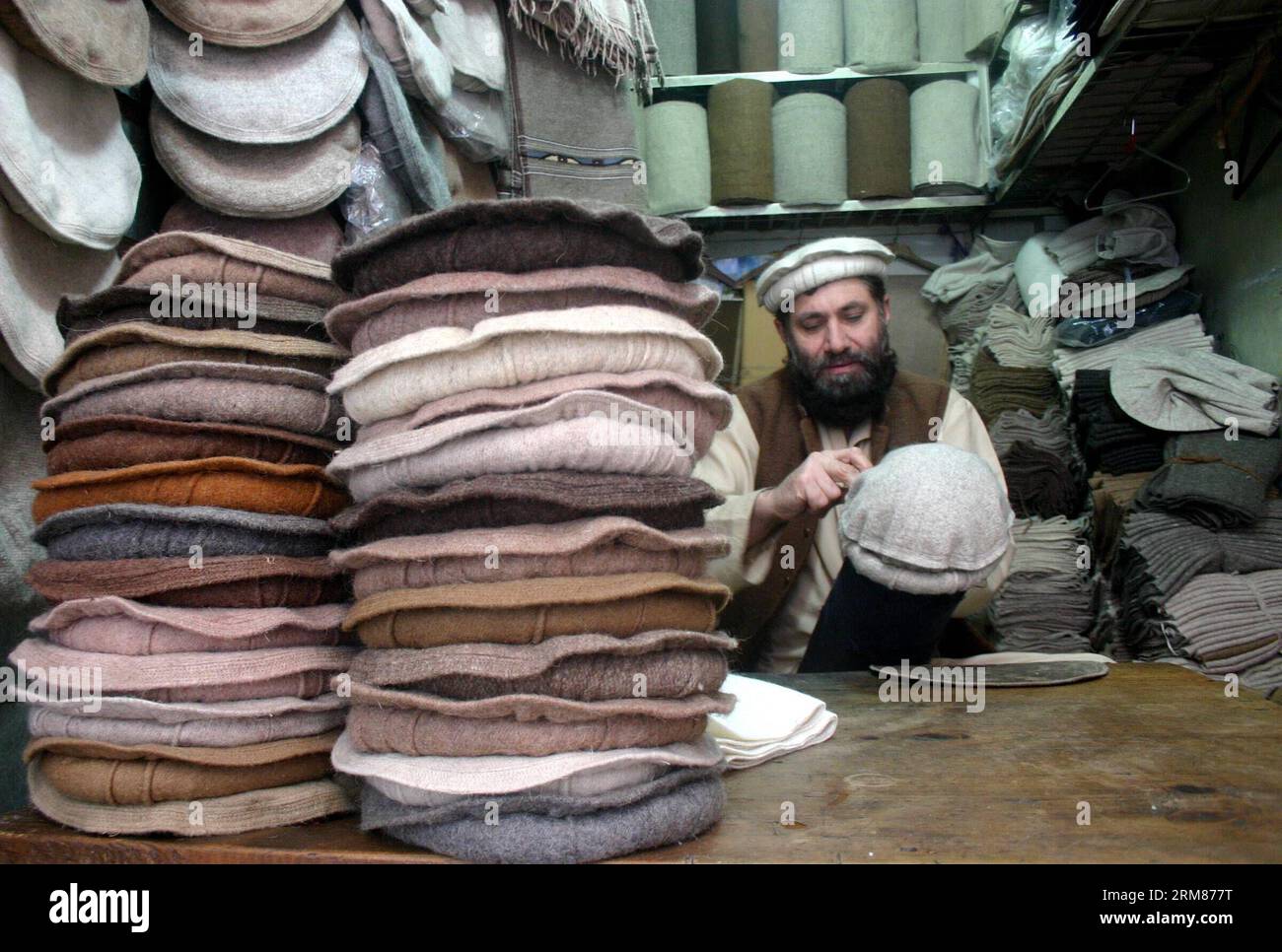 A man knits a traditional cap inside a shop at a market in northwest ...