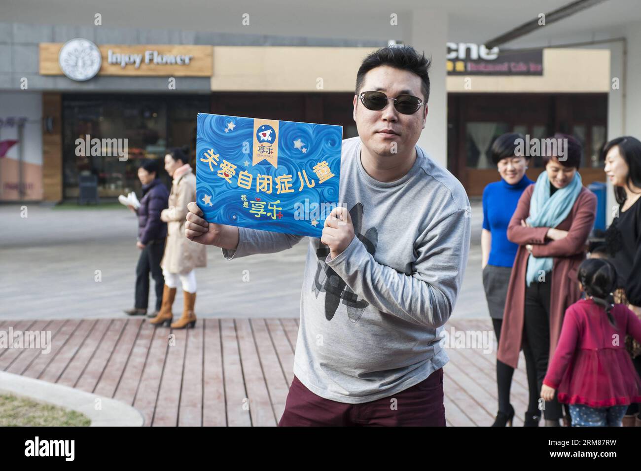 BEIJING, 2014 - Cheng Lei, a volunteer for autistic children, holds a ...