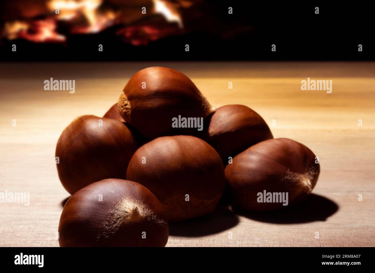Christmas chestnuts ready to roast with an open fire behind Stock Photo ...