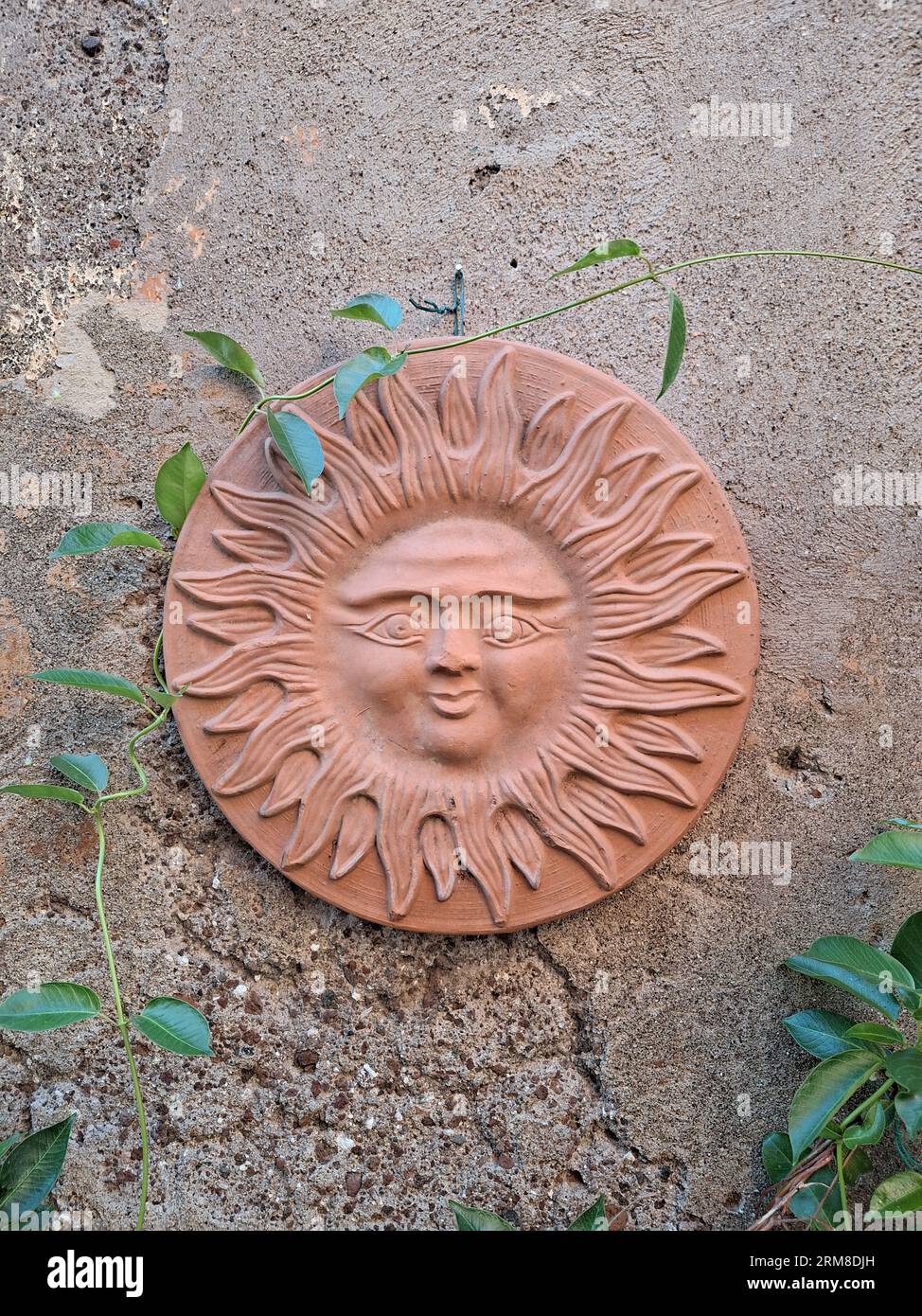 Clay tile with the symbol of the sun Stock Photo - Alamy