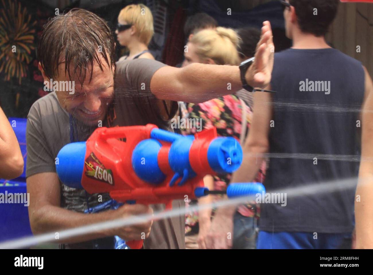 A tourist takes part in a water gun battle during celebrations for ...