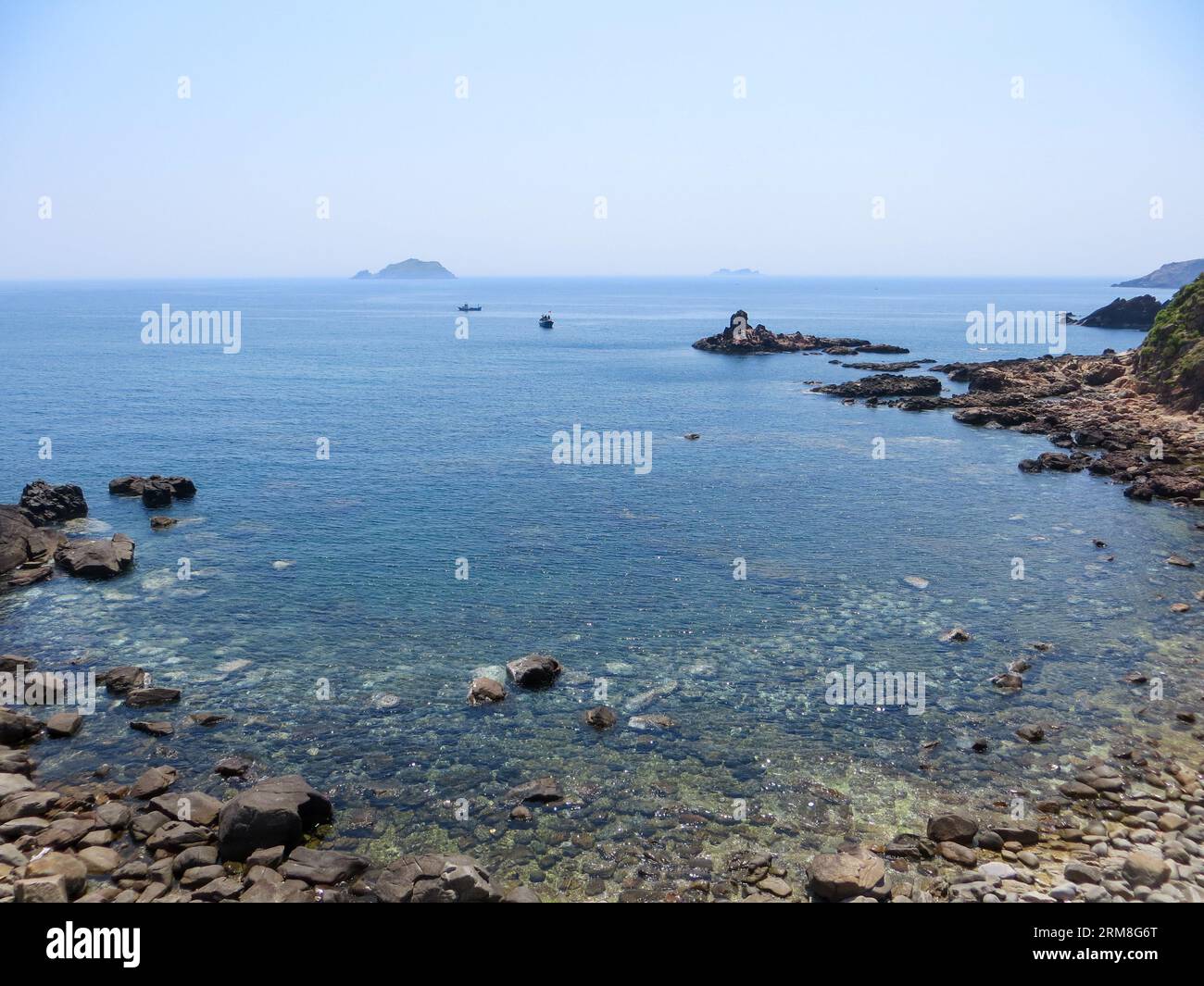 Fishing boats on the South China Sea off the rocky shore of Eo Gió in ...