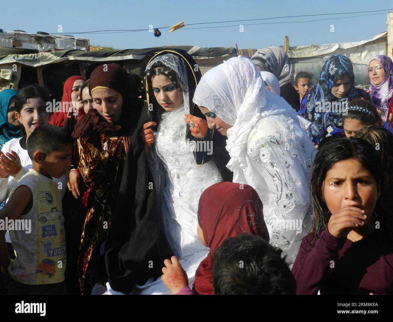 A Syrian bride (C) is surrounded by relatives and friends during her ...