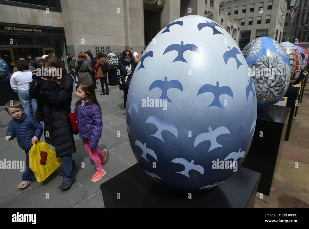 People walk past egg sculptures at the Rockefeller Center in the New ...
