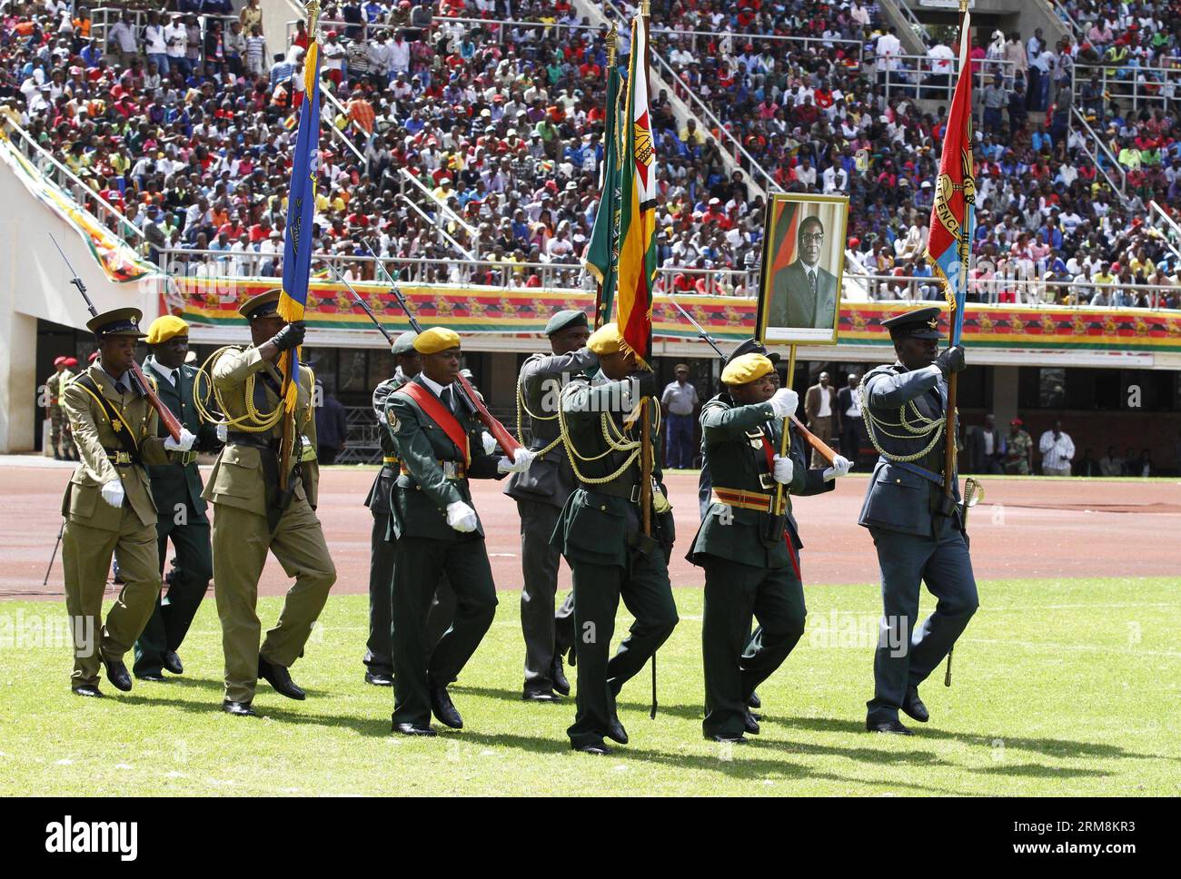 Guards of honor carrying a photo of President Robert Mugabe and flags ...