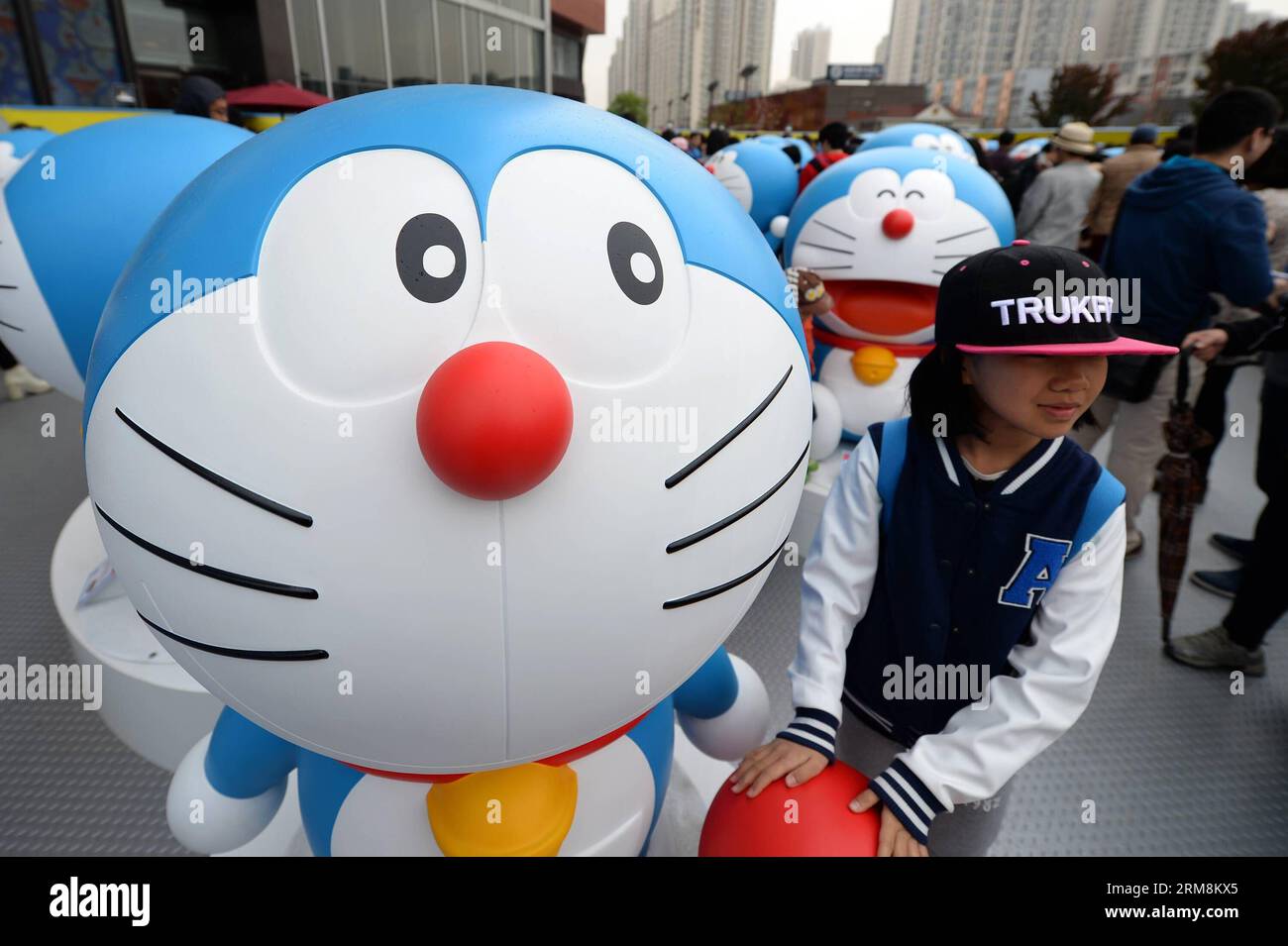 A visitor poses for a photo with a Doraemon figure at an exhibition of ...