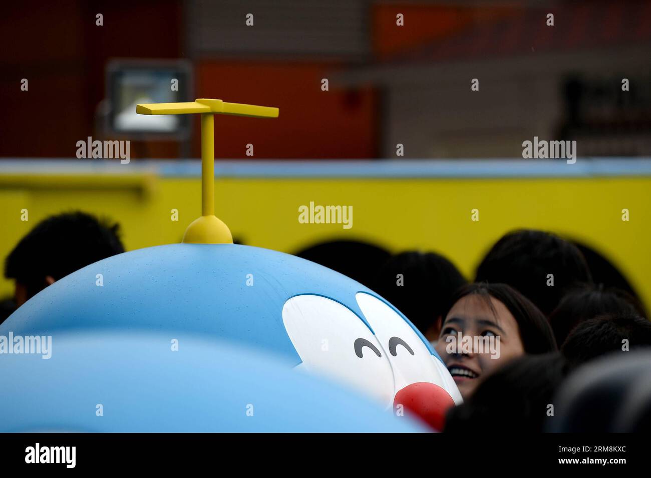 A visitor views a flying device on the head of a Doraemon figure at an ...