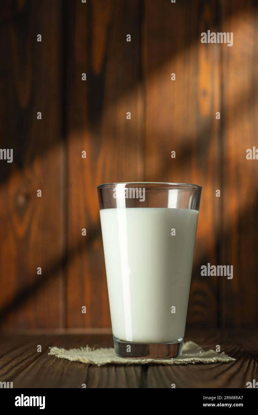 glass of milk on wooden table with sun rays Stock Photo - Alamy