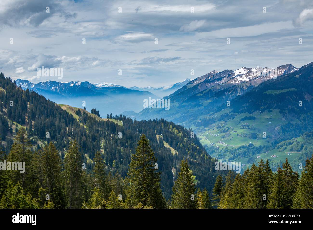 Spring sunlight illuminating the forests, farms and the partially snow ...