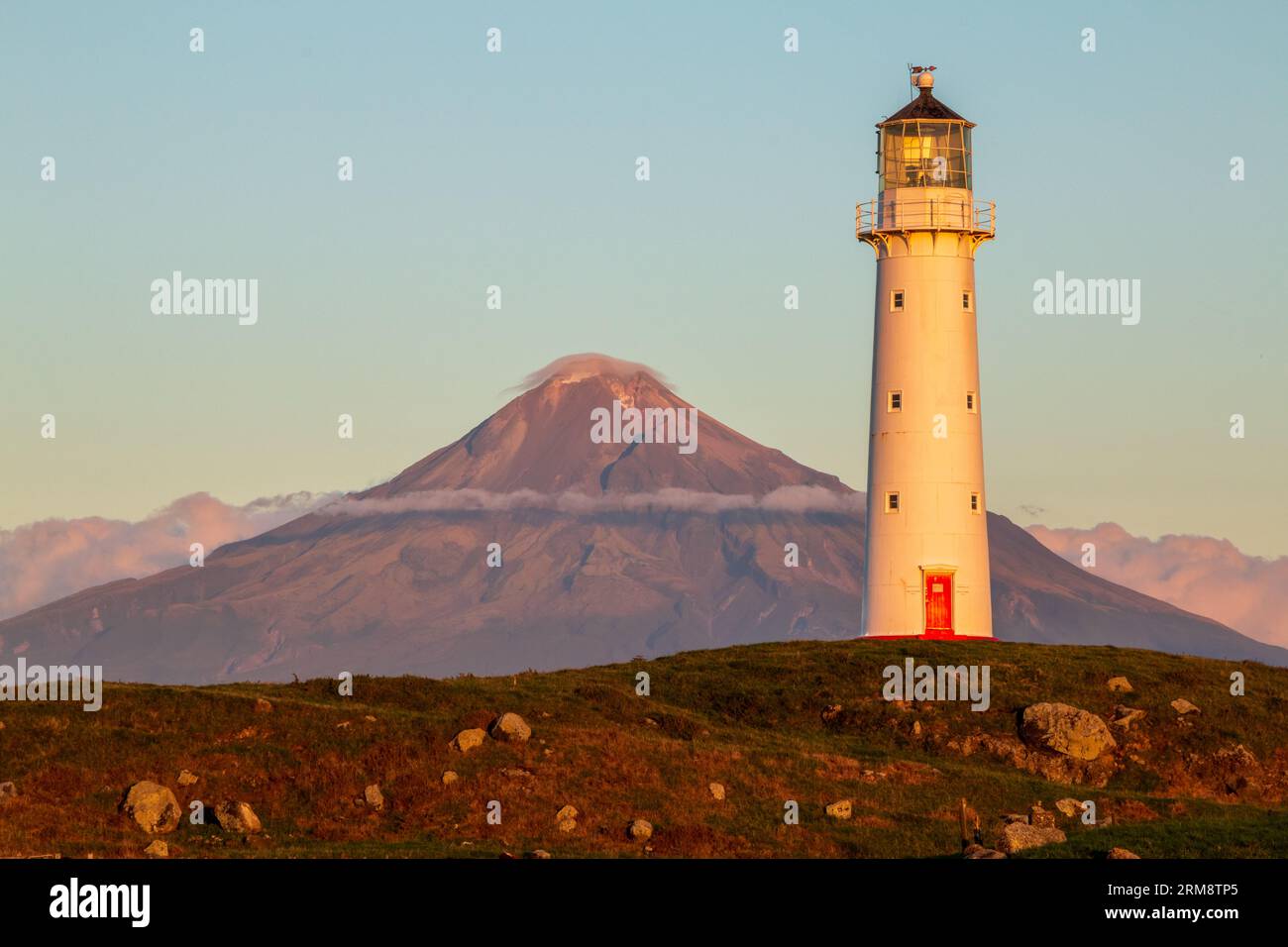 Stunning sunset view of Cape Egmont Lighthouse in front of Mt Taranaki ...