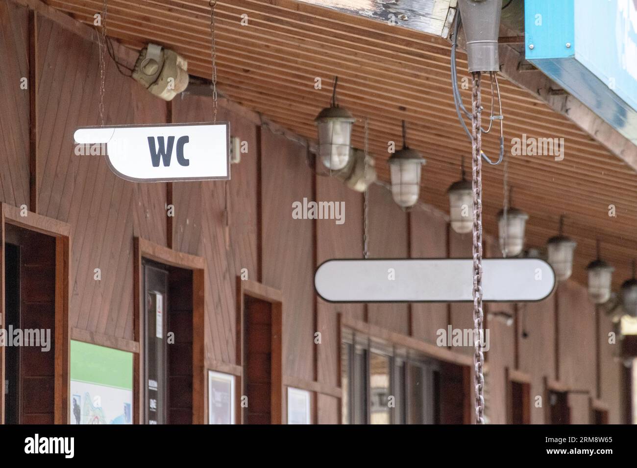 signs hang on a metal chain near the House Stock Photo - Alamy