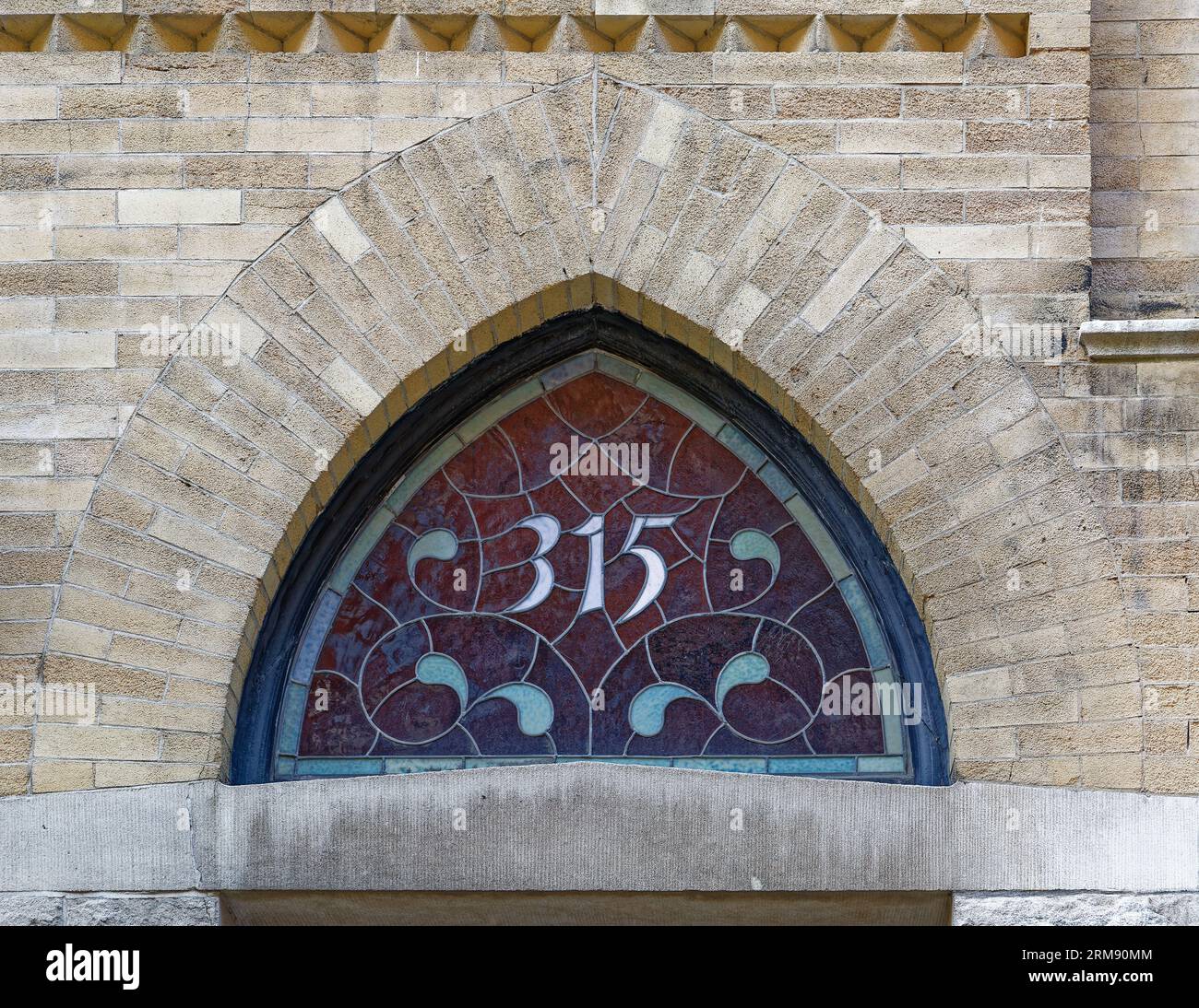 Upper West Side: Gothic-arched stained glass fan light set in brick ...