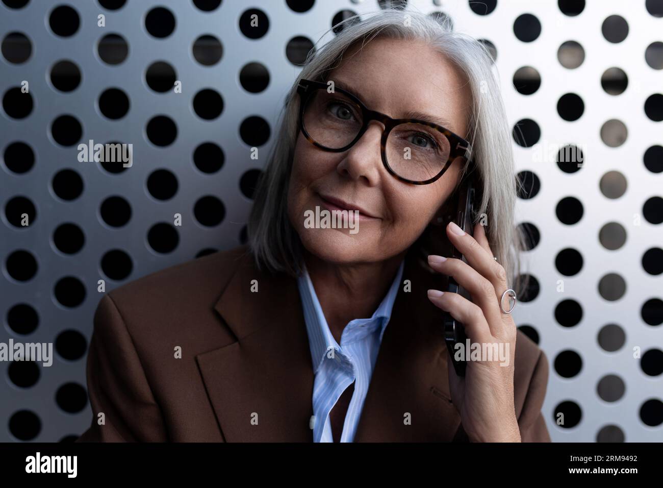 confident 60 year old gray-haired business woman with a bob haircut is ...