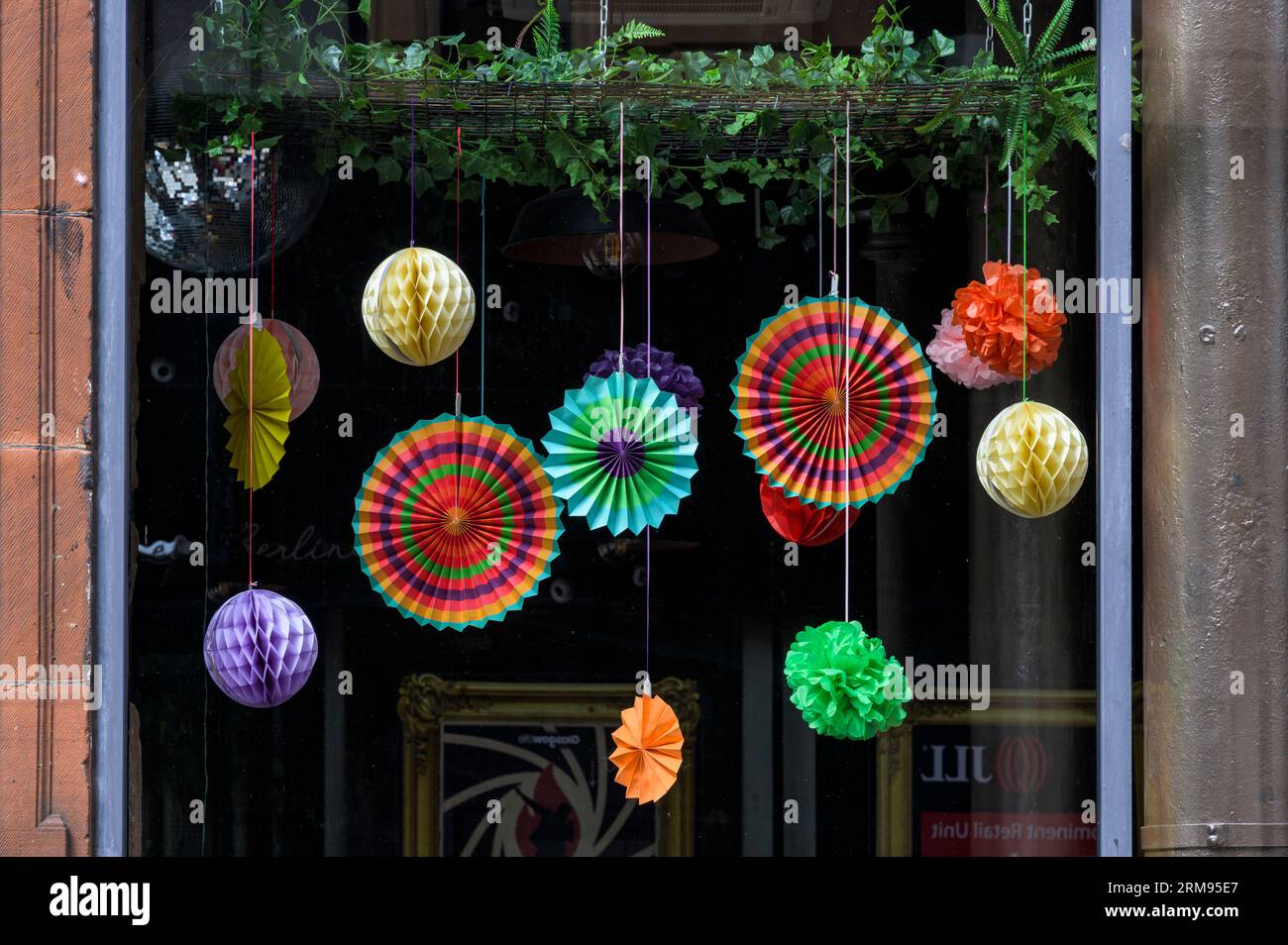 Paper decorations hanging on display in a window Stock Photo - Alamy