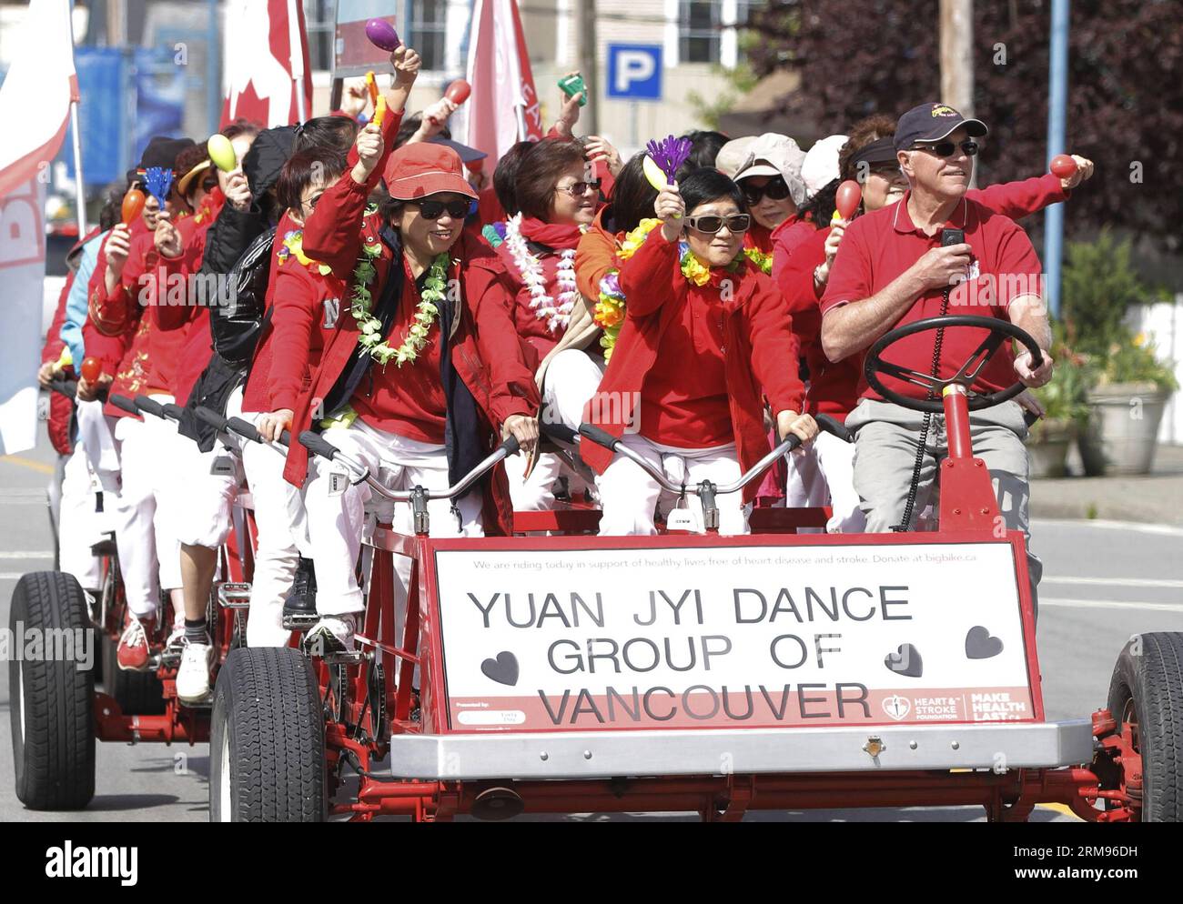 People take a ride with the big bike along the street in Richmond ...