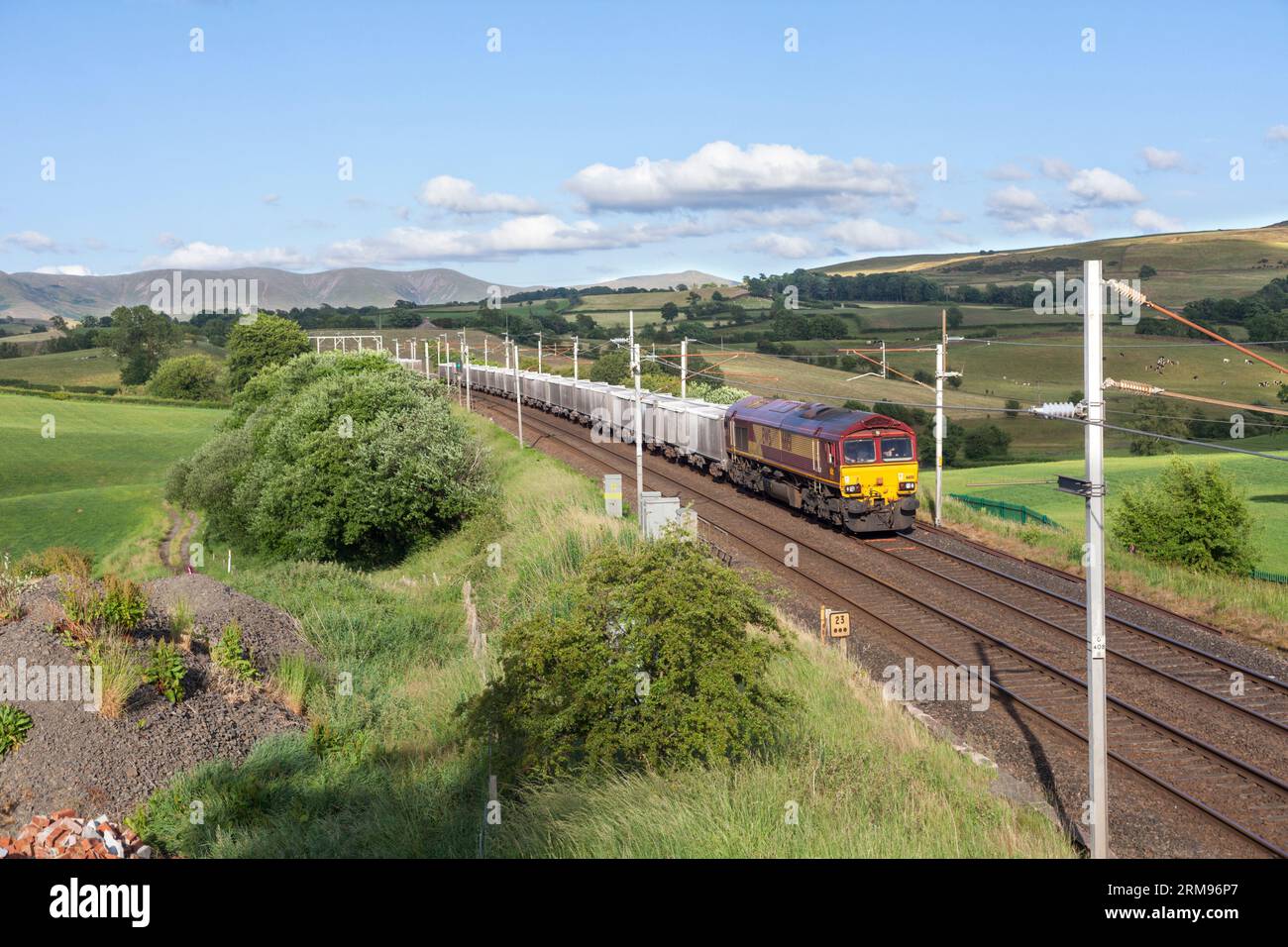 DB Cargo class 66 locomotive in EWS livery passing Docker (north of ...