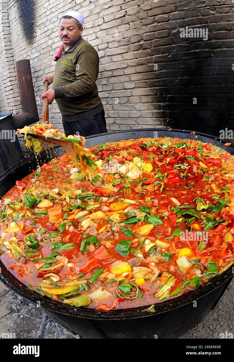 Photo taken on Oct. 20, 2011 shows a man cooking food in a giant pan in ...