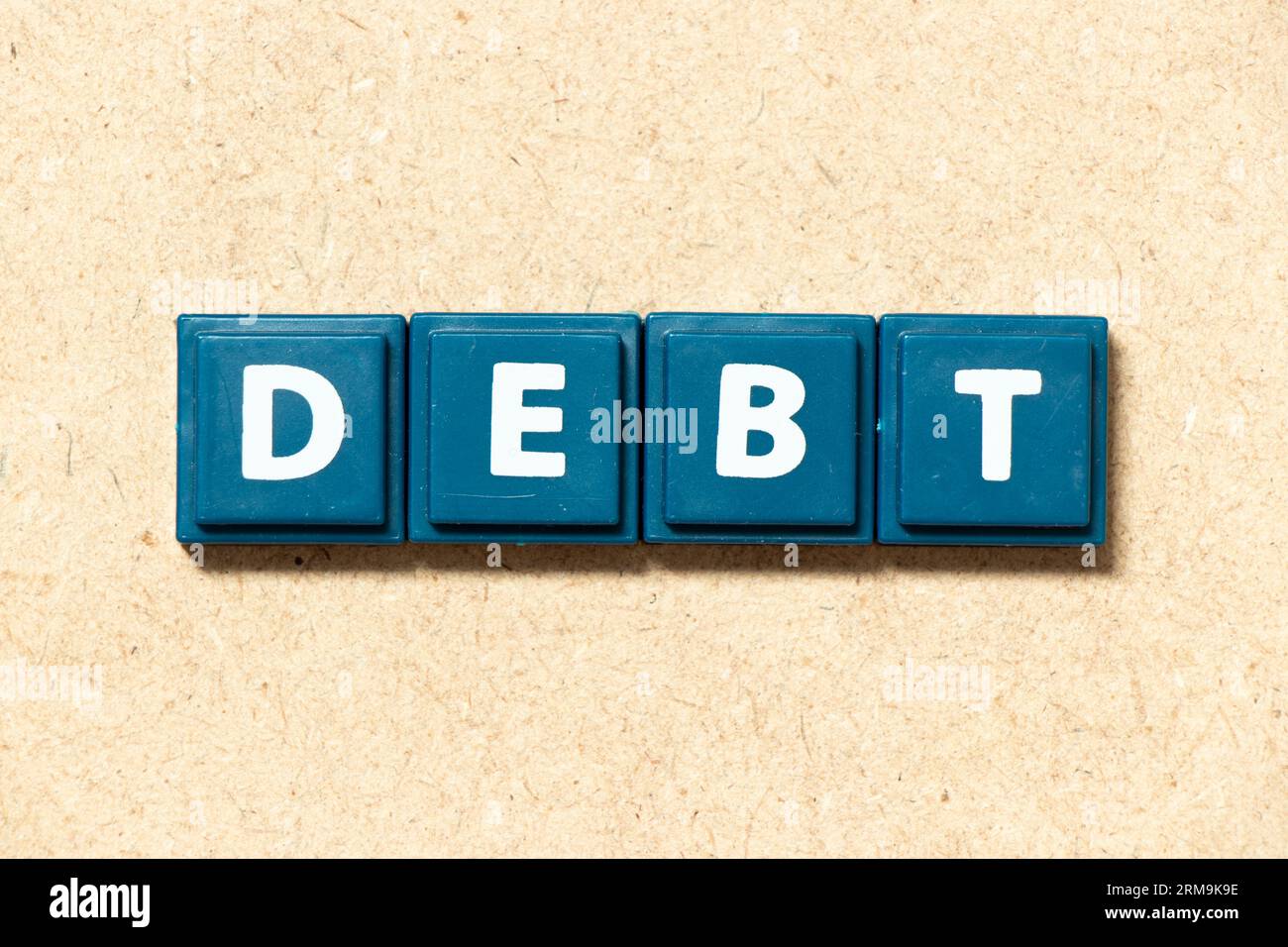Tile alphabet letter in word debt on wood background Stock Photo - Alamy