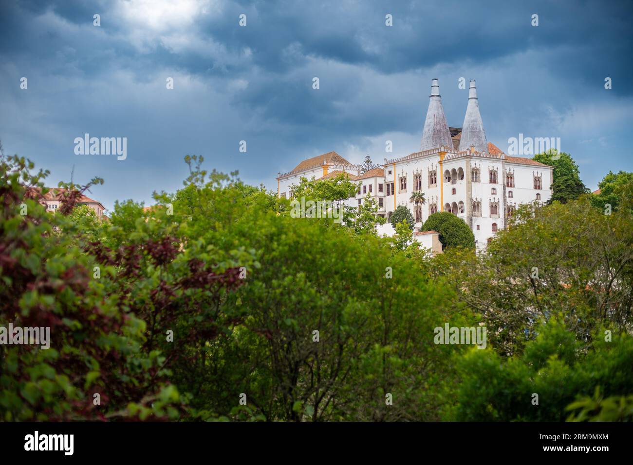An ancient castle featuring multiple spires atop a rolling hill ...
