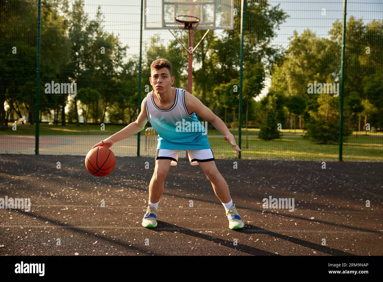 Boy dribbling basketball on outdoor court hi-res stock photography and ...