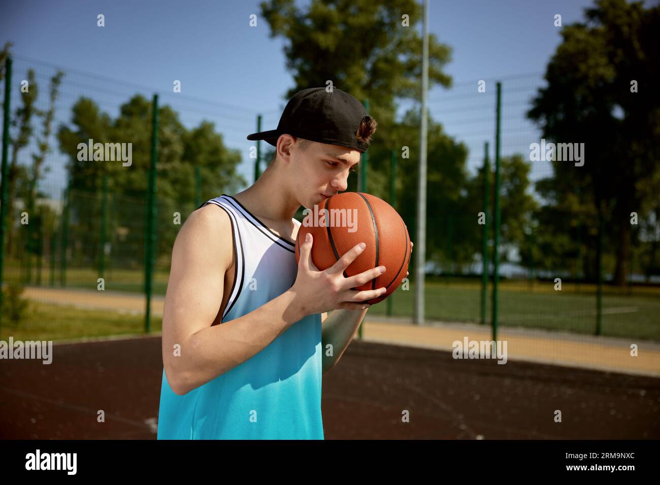 Teenager basketball player kissing ball praying for score goal Stock ...