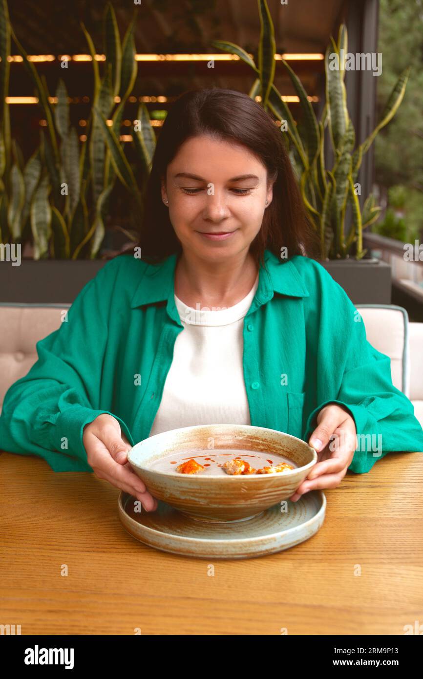 woman enjoy to eat soup for lunch in vegetarian green cafe - mushroom ...