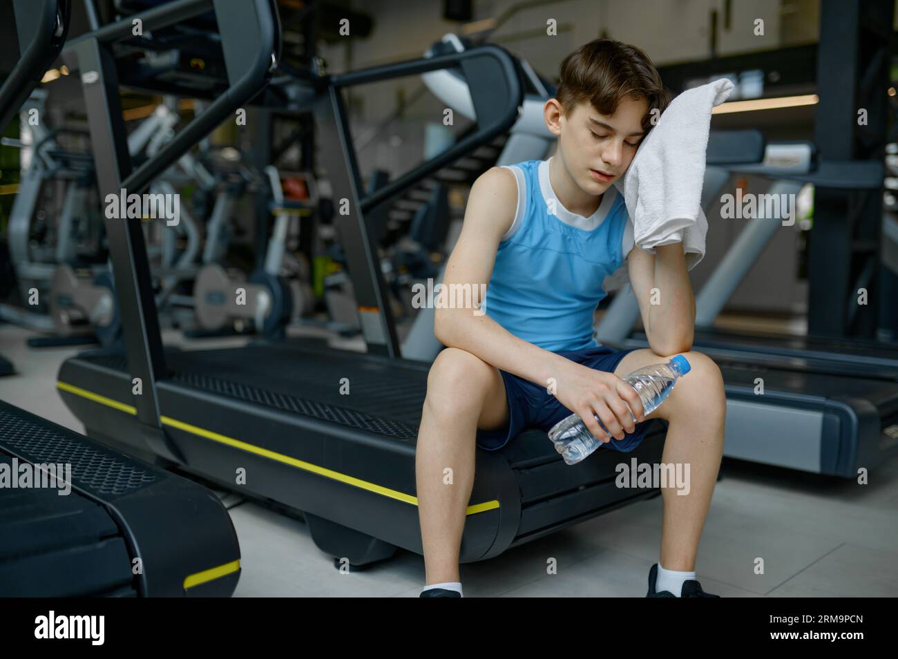 Preteen boy rest after hard training workout on treadmill at gym Stock ...