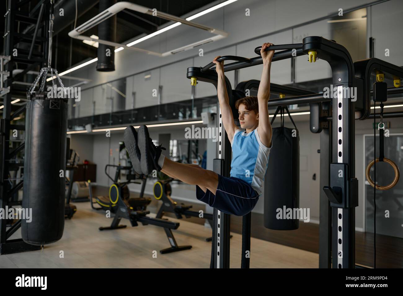 Teenager boy pulling up on crossbar over gym background Stock Photo - Alamy