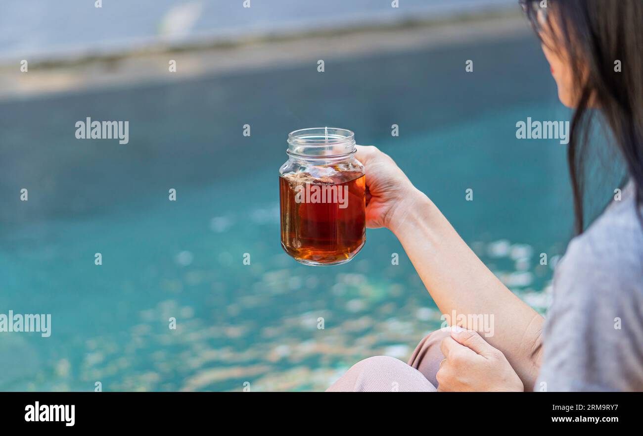 holding a cup of a hot tea on swimming pool Stock Photo - Alamy