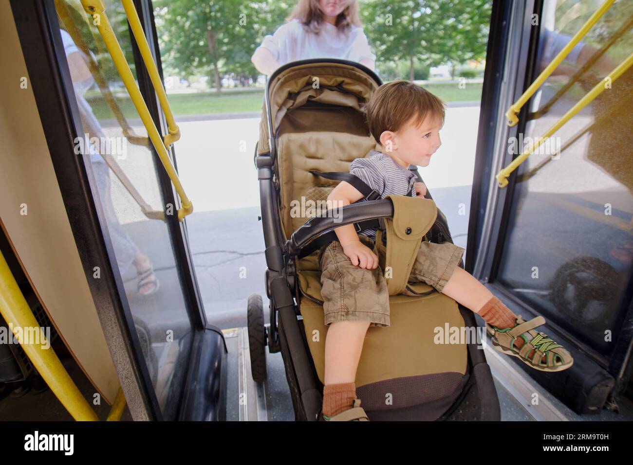 The child is getting on the bus with their mom, ready to board and find ...