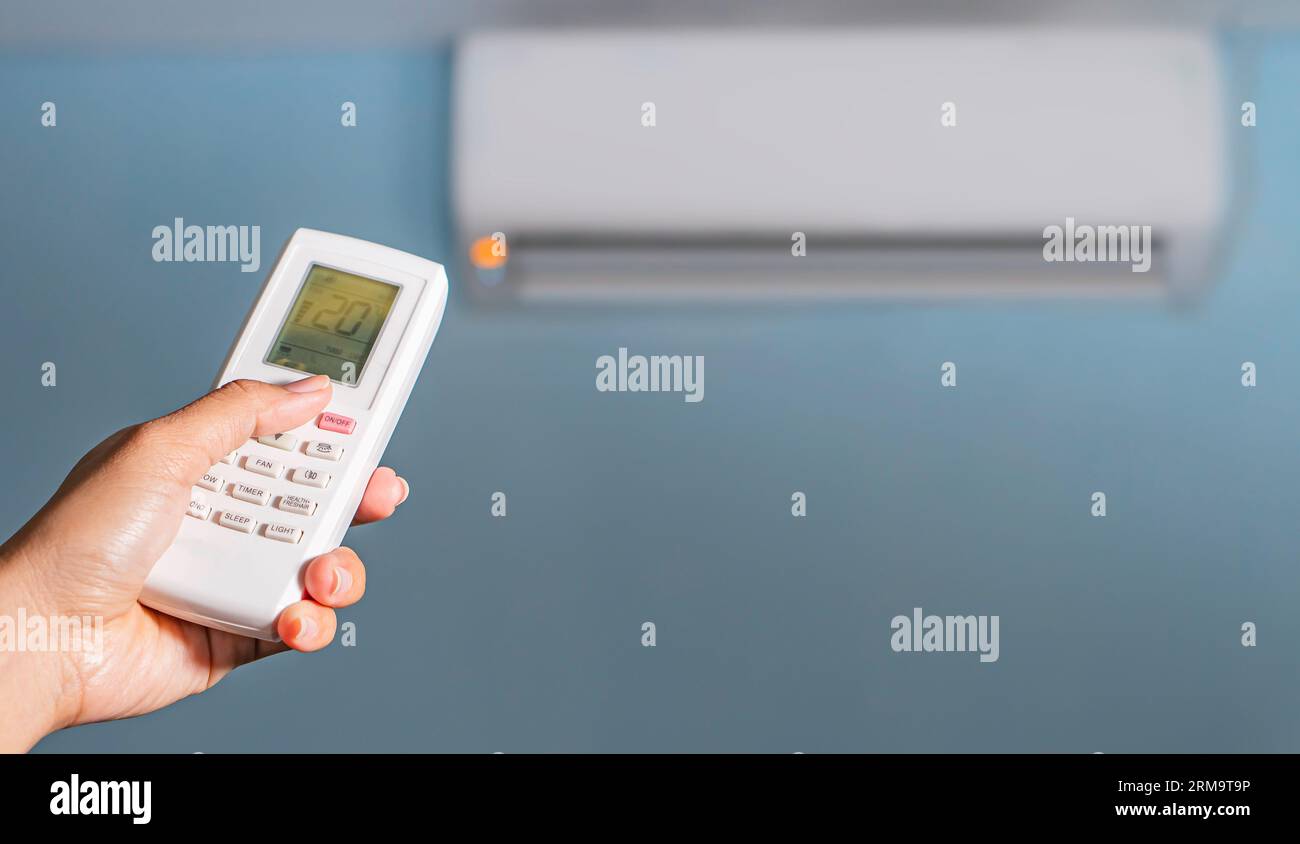 Air conditioner temperature adjustment with remote controller in room ...