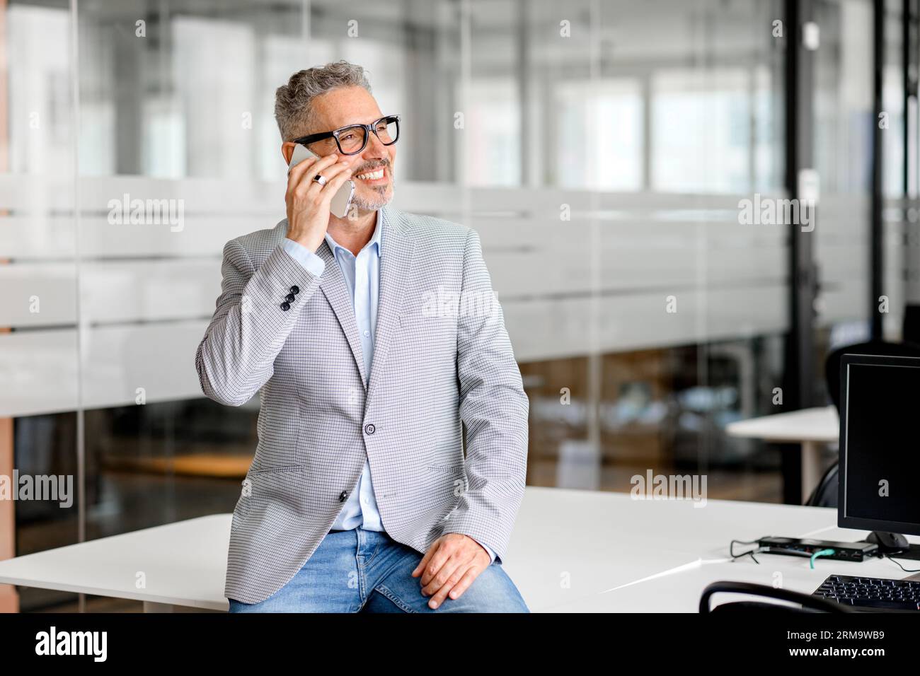 Stylish mature businessman in smart casual wear talking on the ...