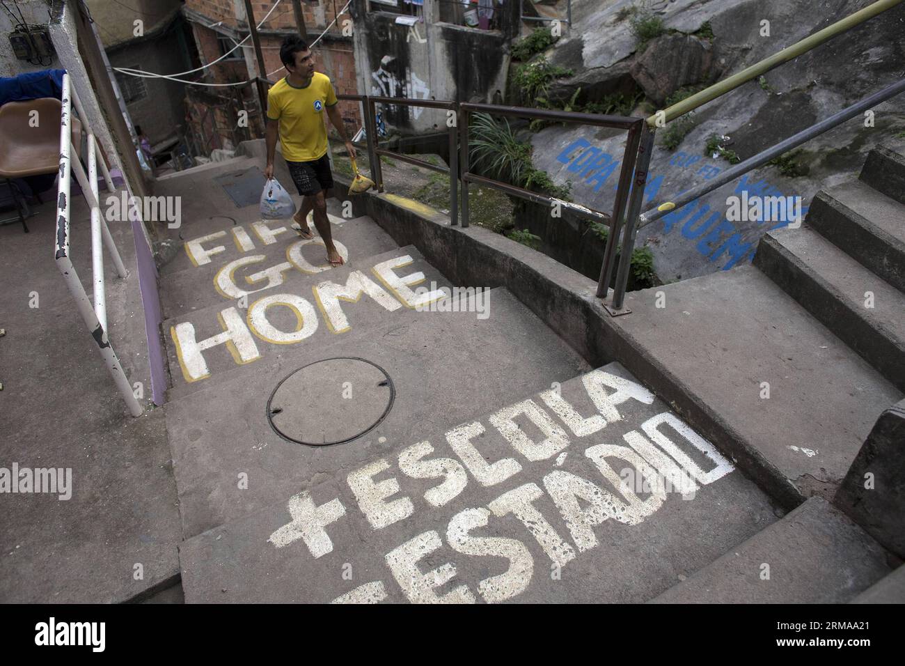 A man walks on a road painted with the slogan against FIFA in Favela ...