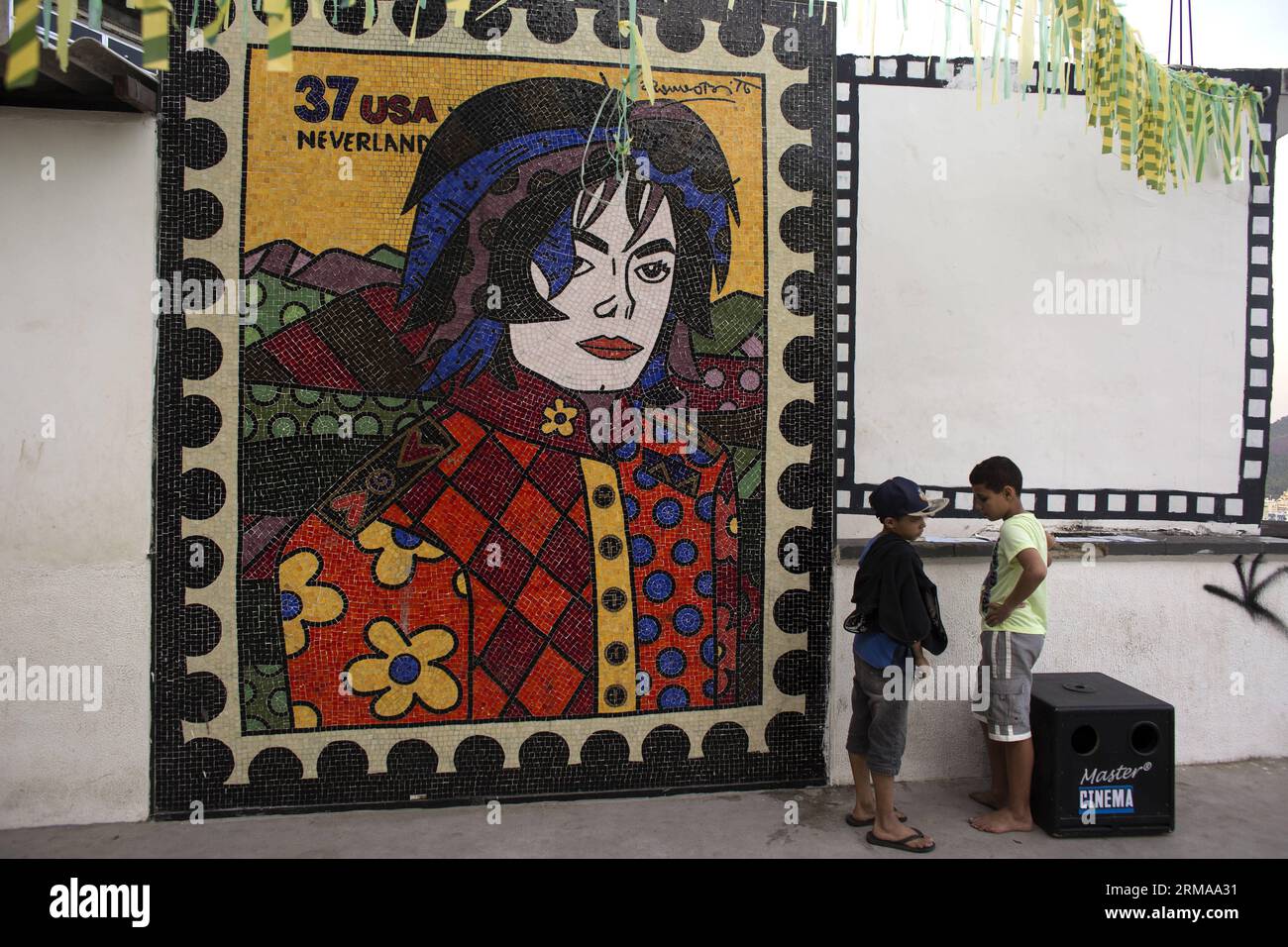 Two boys play near a patchwork with the image of American pop singer ...