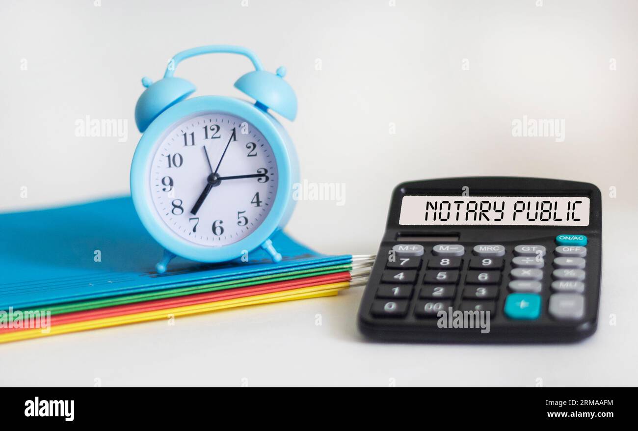 On a light background - an alarm clock, folders and a calculator with ...