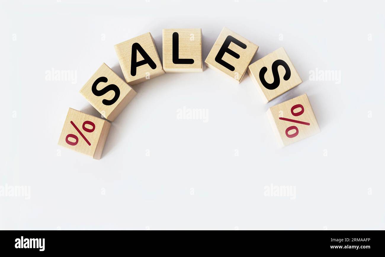 On wooden blocks the text SALE and the percent symbol on a white ...